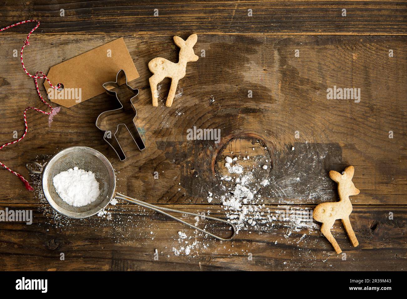 Festive Christmas deer shaped biscuits on a rustic board with cookie ...