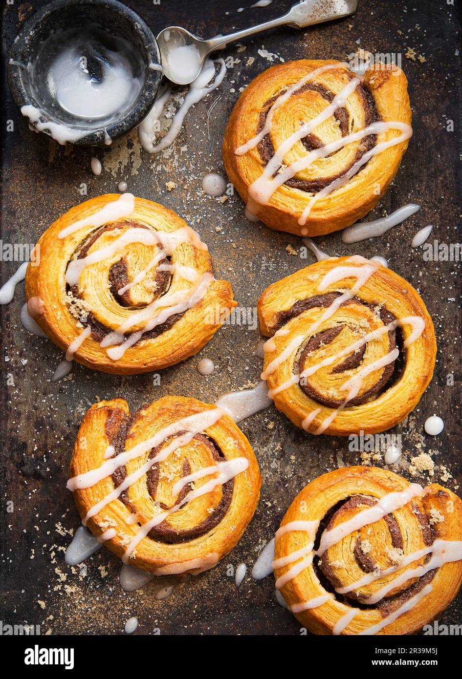 Danish Pastries cinnamon swirls on a baking tray decorated with icing ...