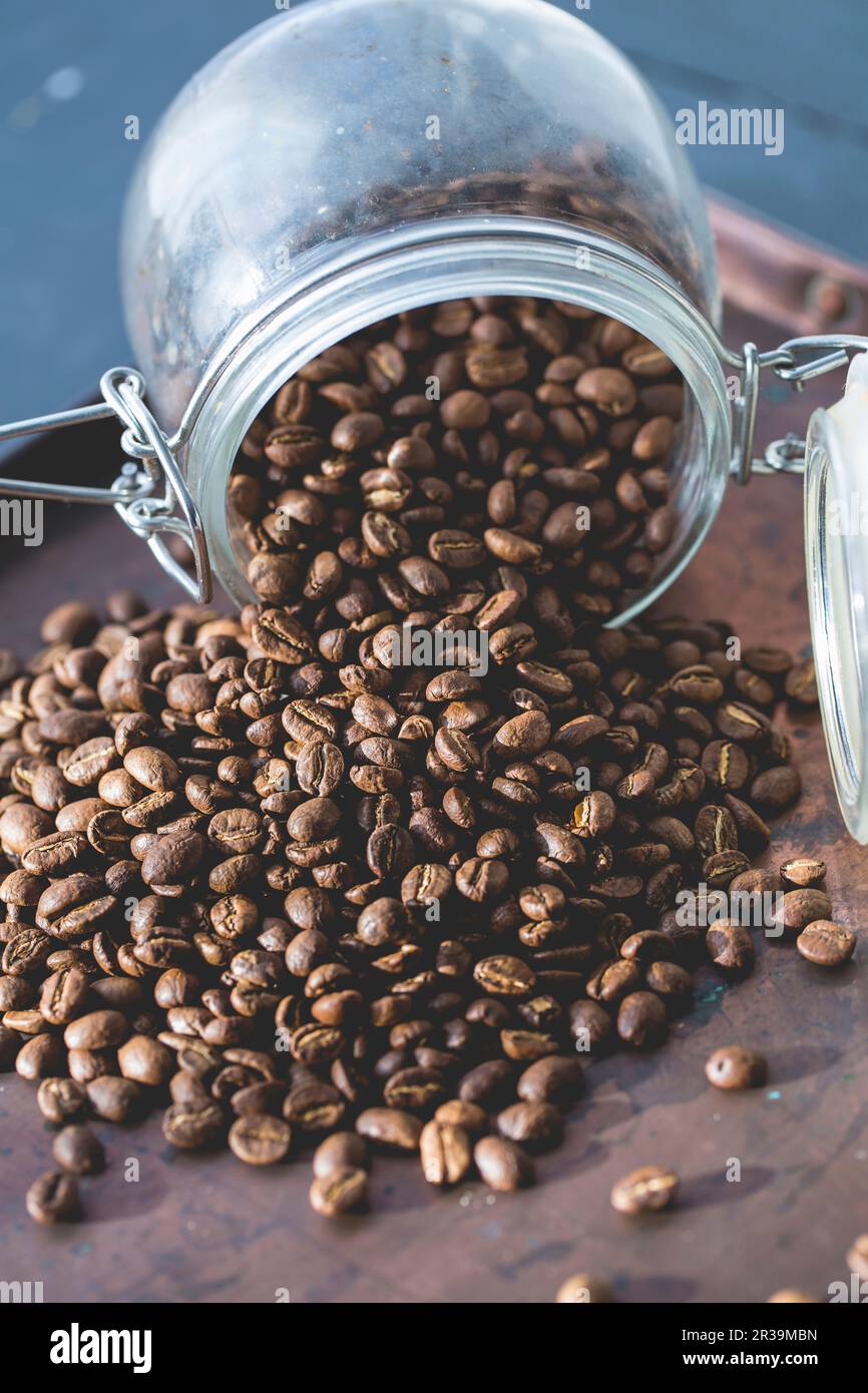 Coffee beans falling out a glass Stock Photo - Alamy