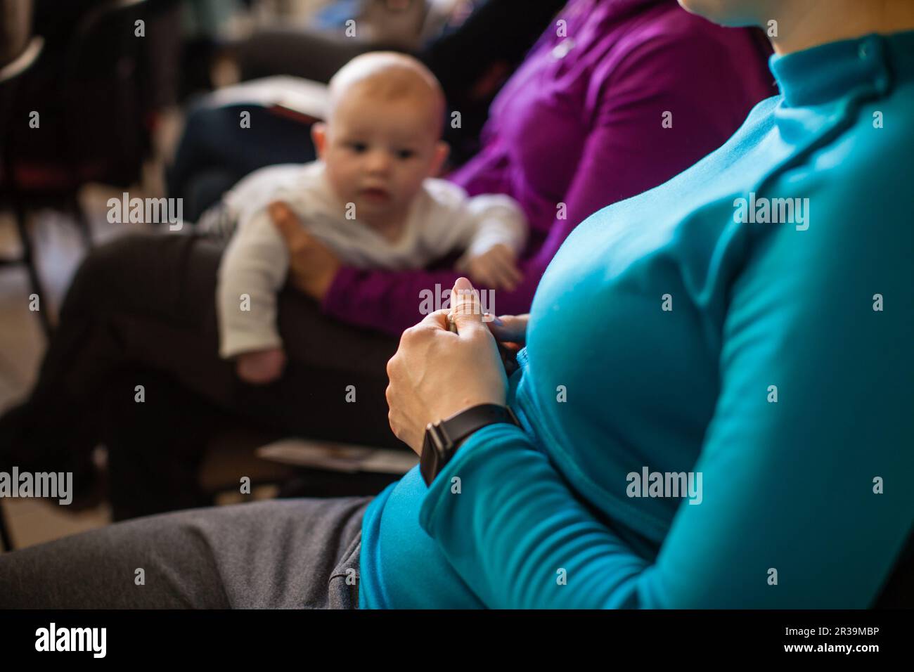 Female participants listening to lecture. Mother with baby at workshop ...