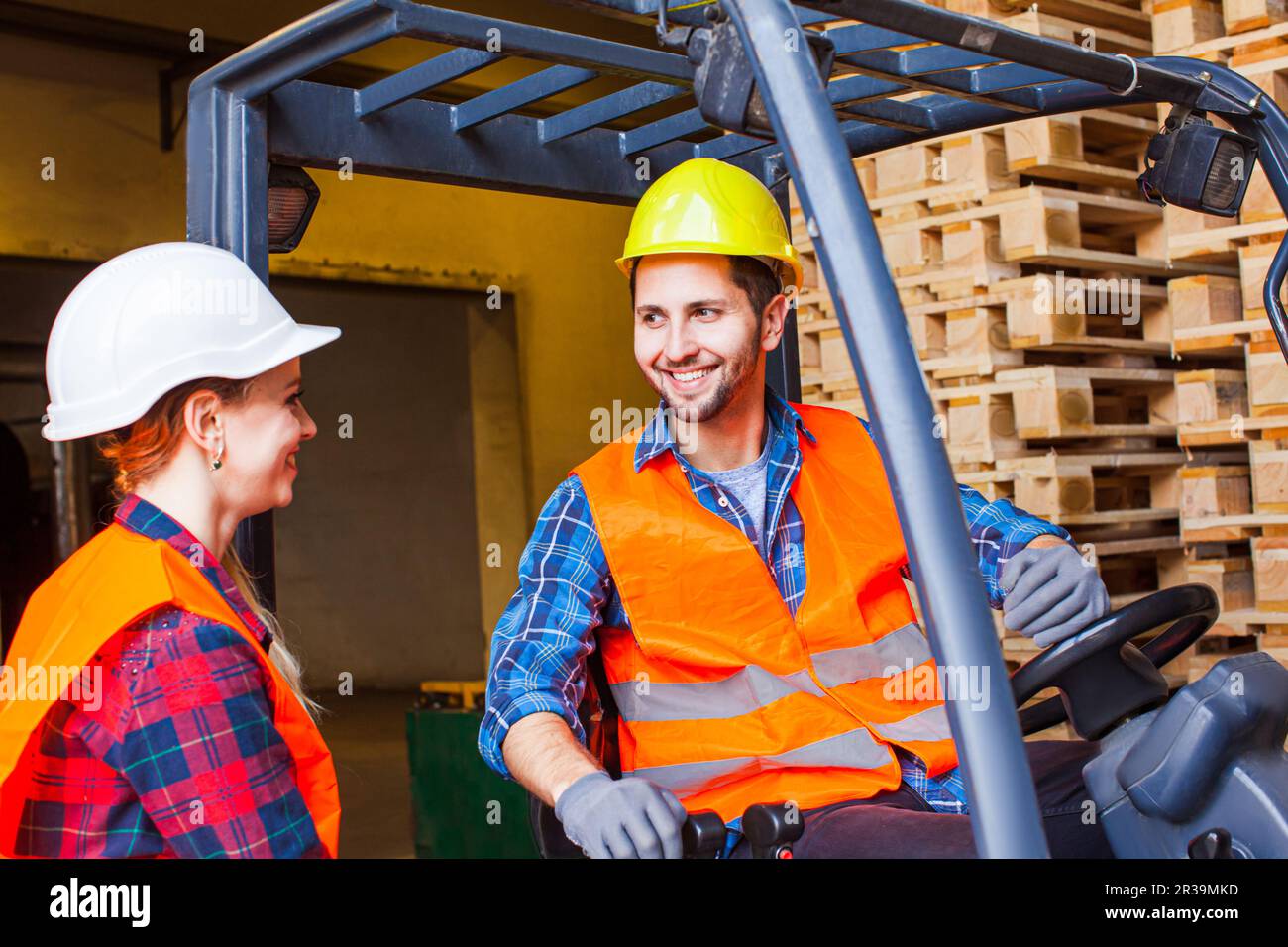 Warehouse manager checking order list. People in protective helmet ...