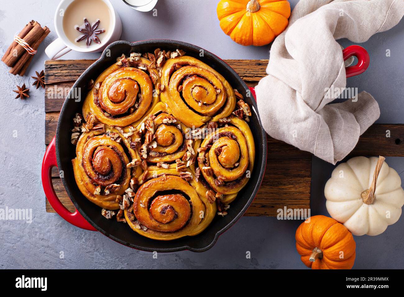 Pumpkin cinnamon rolls in a cast iron pan with nuts and sugar glaze ...