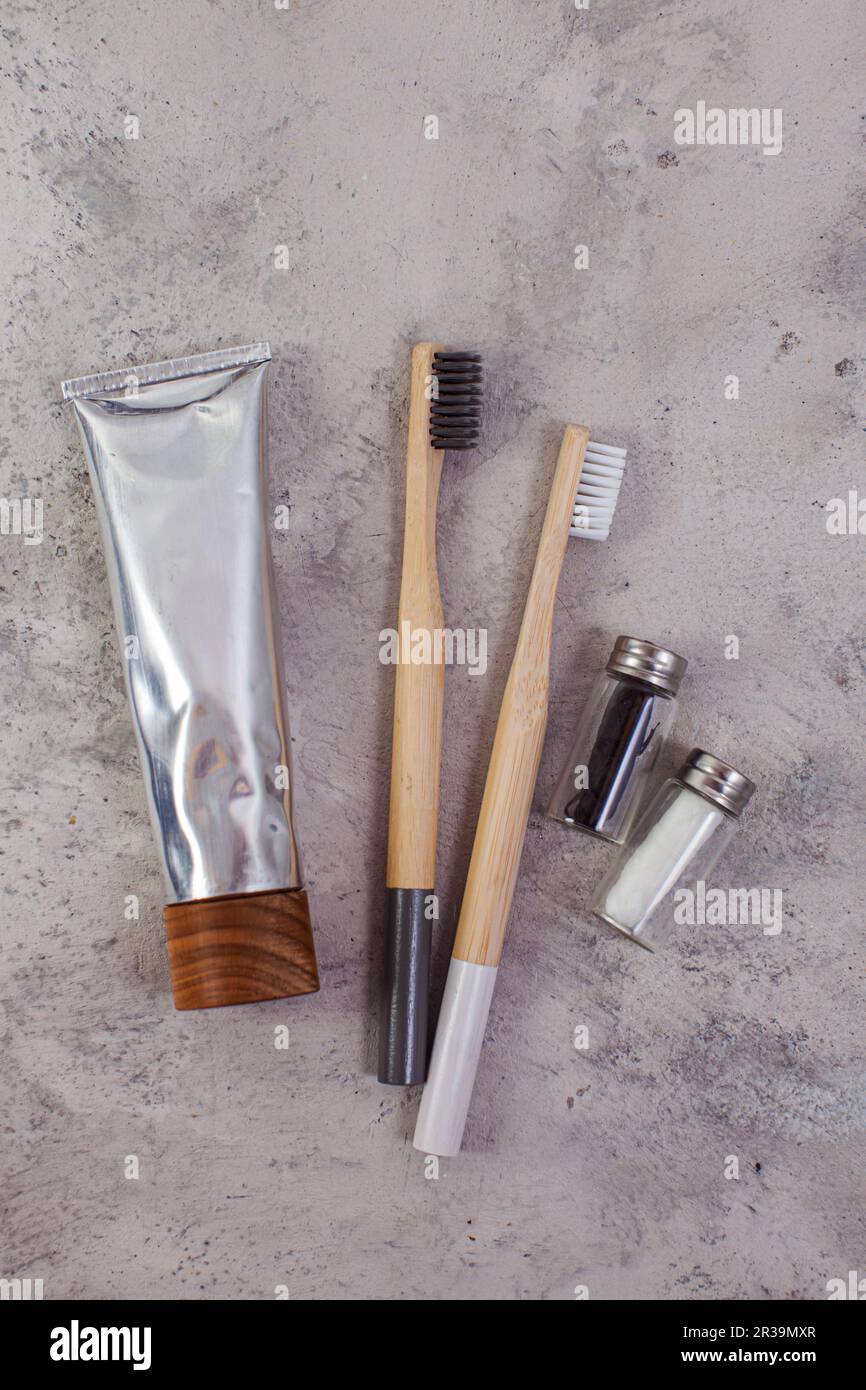 Natural bamboo toothbrushes, toothpaste, floss on grey marble ...
