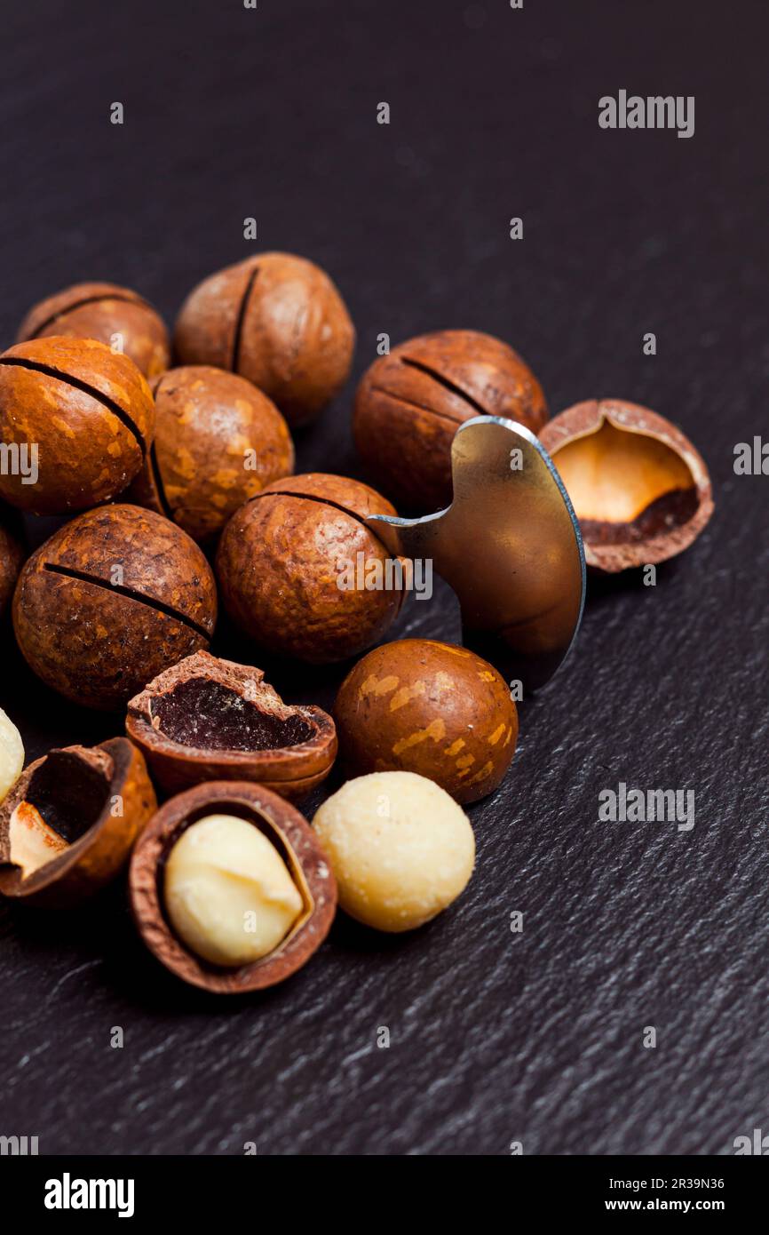 Whole and open macadamia nuts with key on black background Stock Photo ...