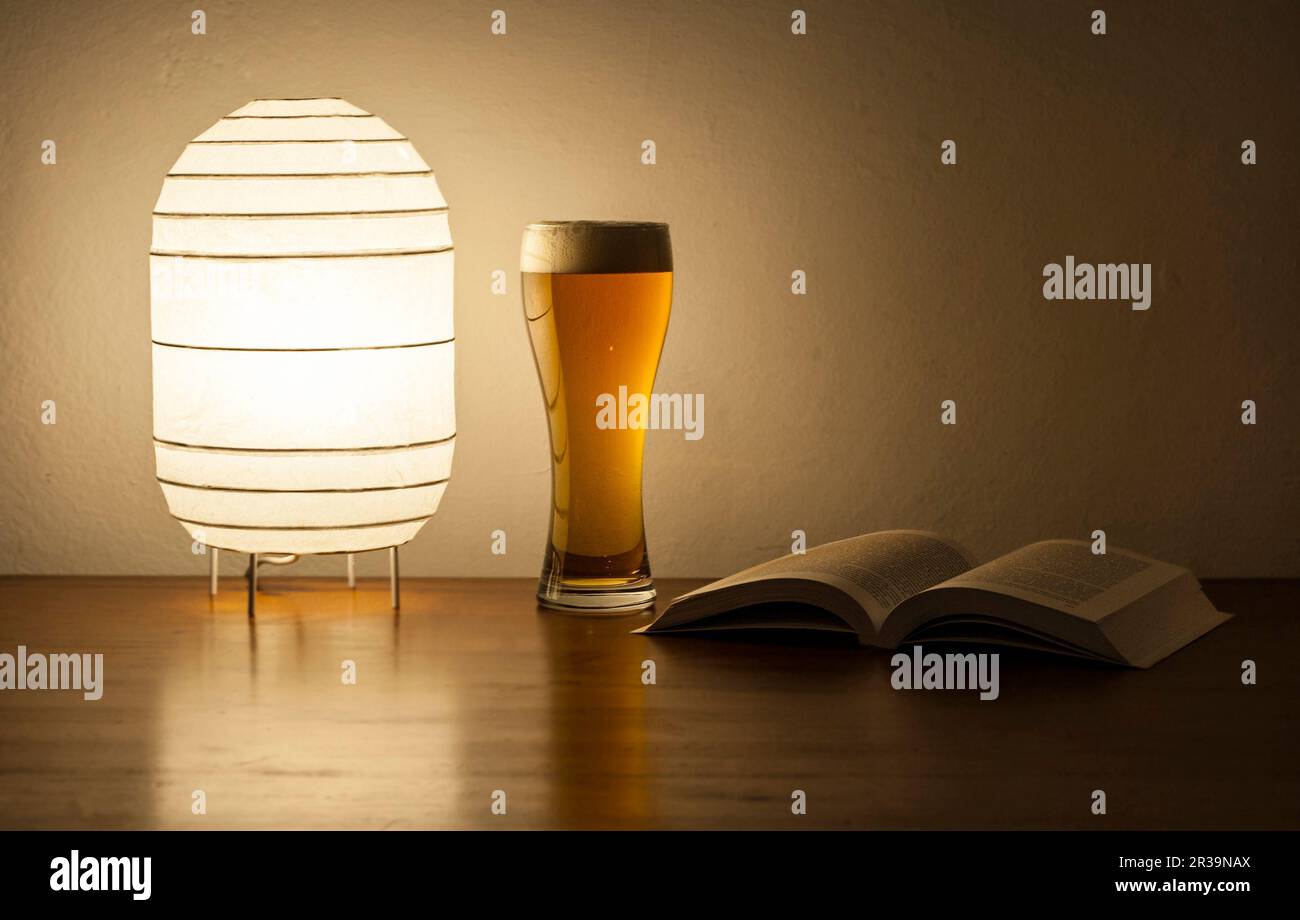 Lamp book and beer on desk Stock Photo - Alamy