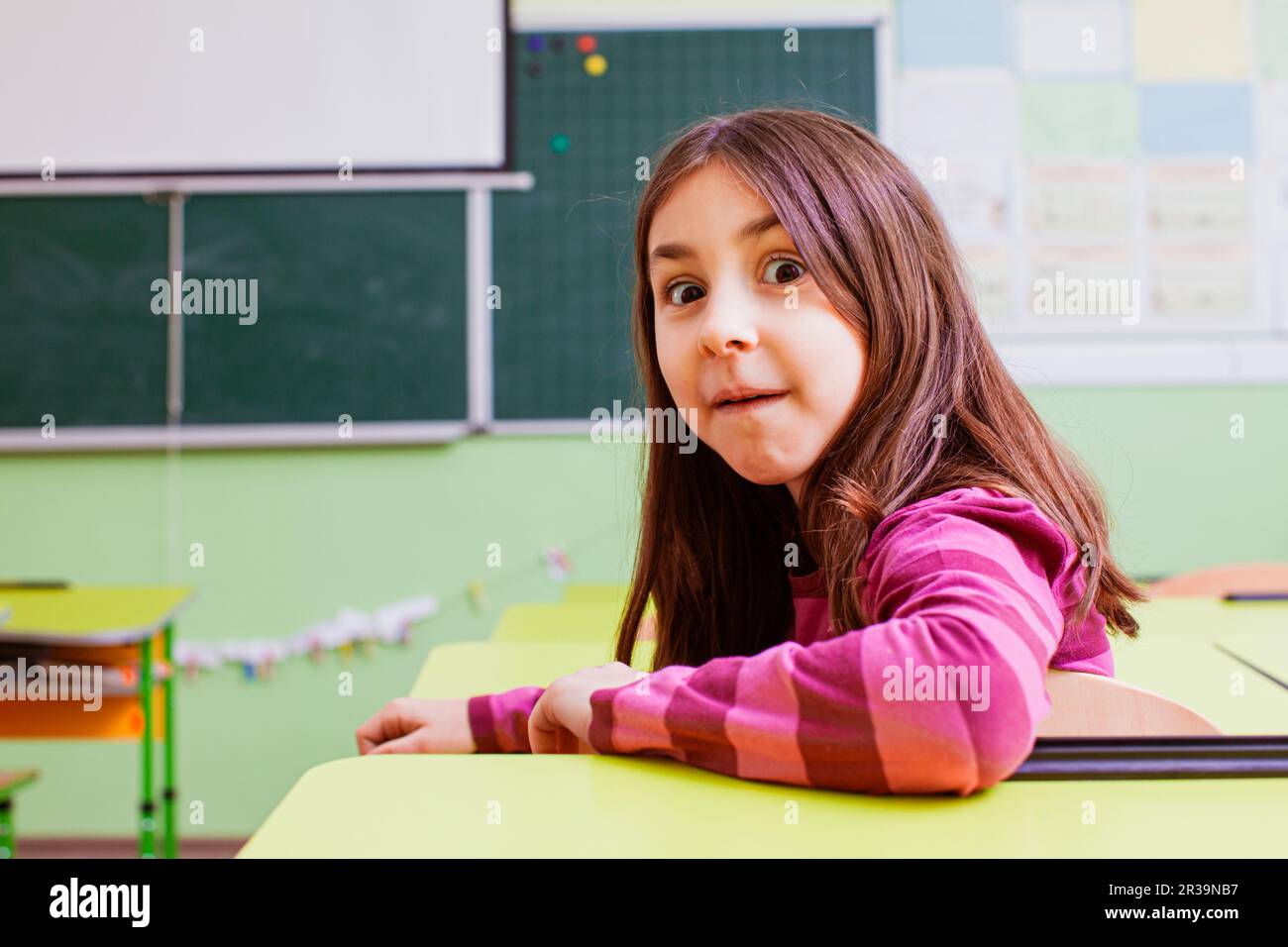 Cute girl with funny face in empty classroom Stock Photo - Alamy