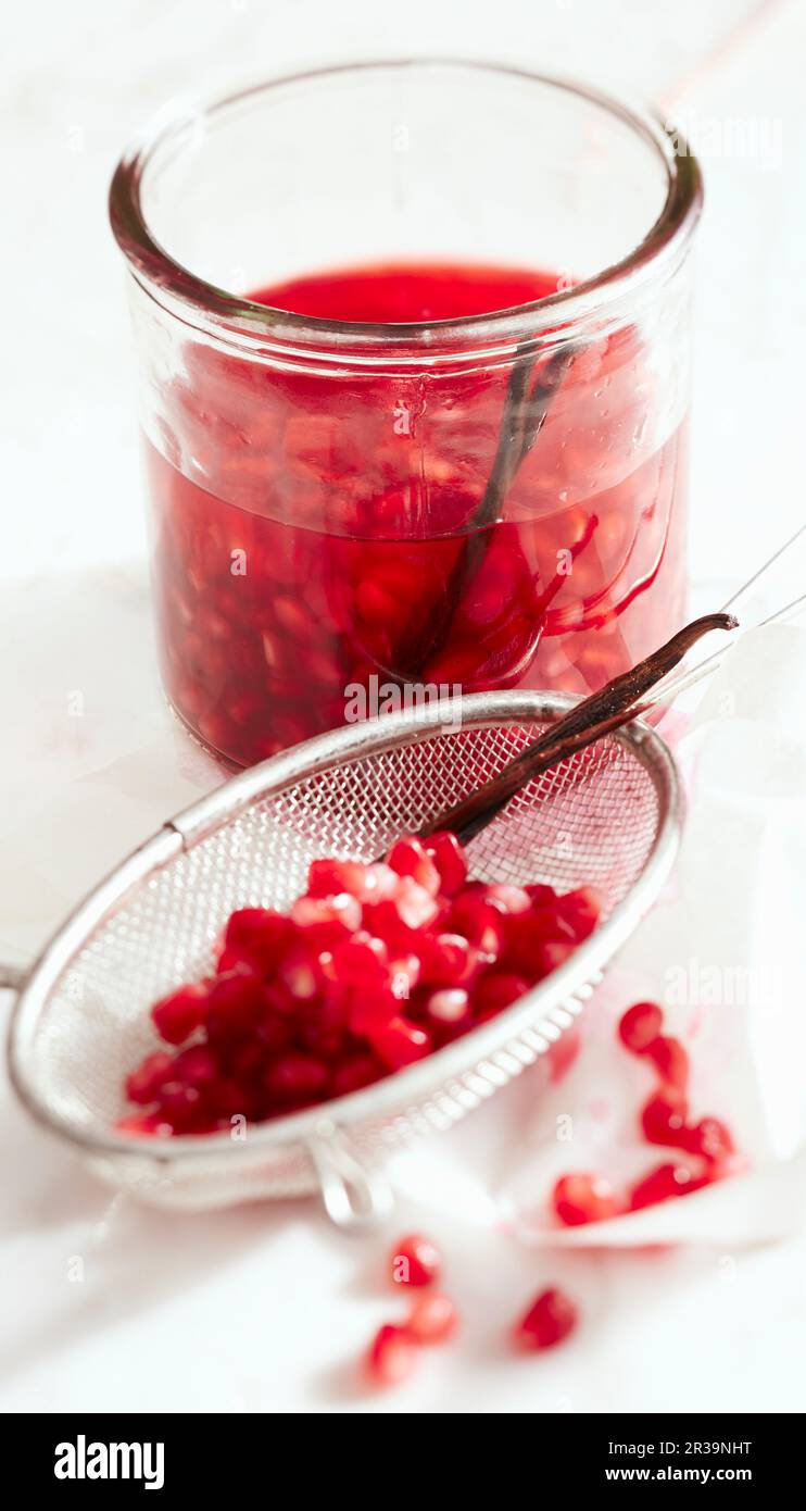 Homemade pomegranate essence in a jar with vanilla and balsamic vinegar ...