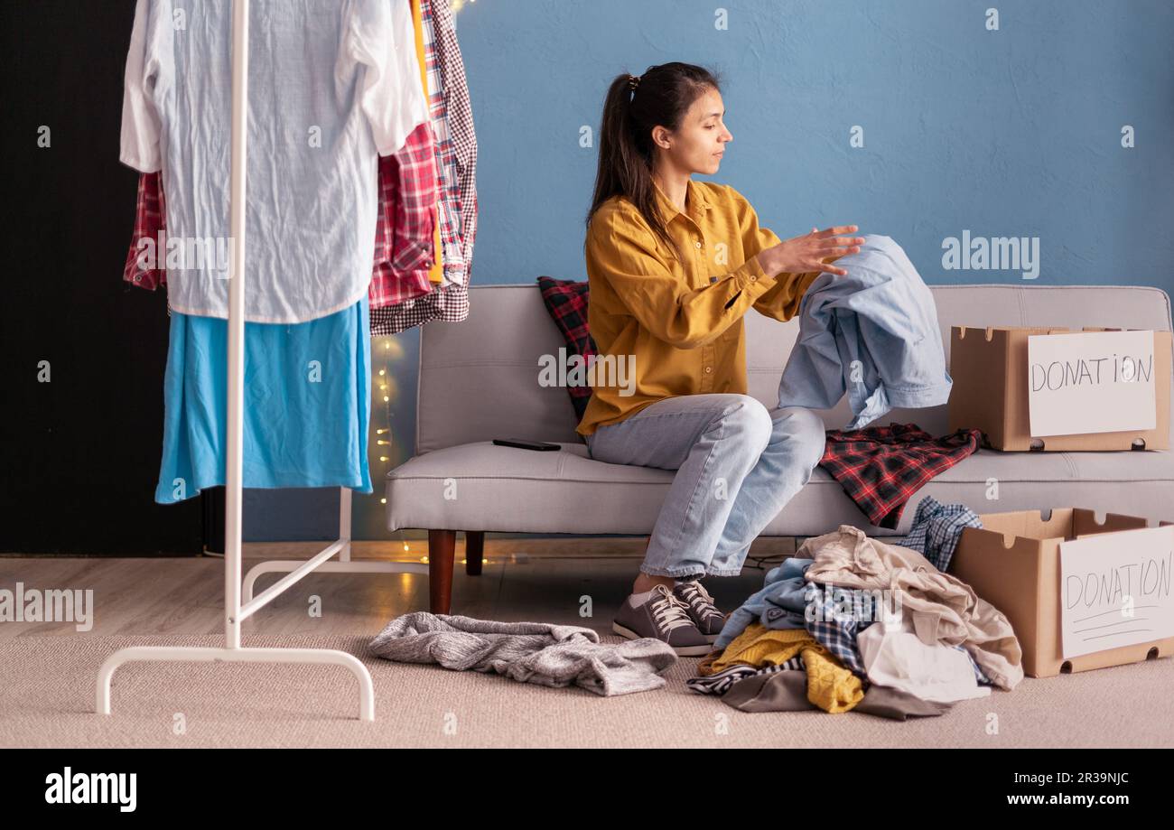 Woman packing clothes on donate box in her room, Donation and charity ...