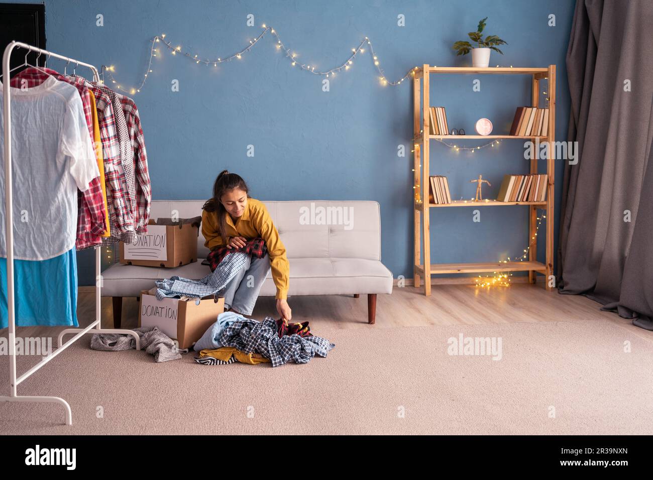 Woman sorting and packing clothes on donate box in her room, Donation ...