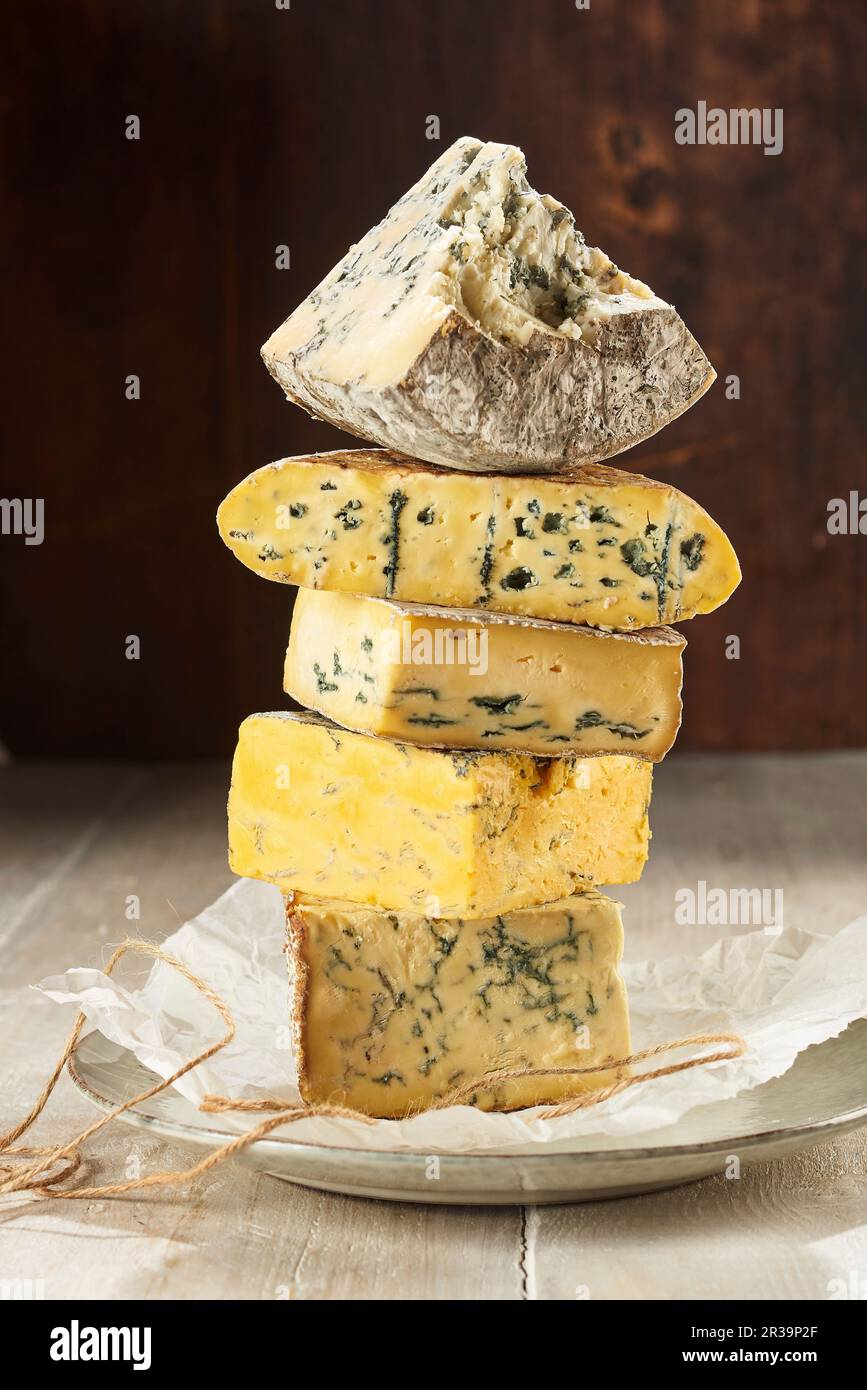 Selection of blue cheeses stacked up on paper Stock Photo - Alamy