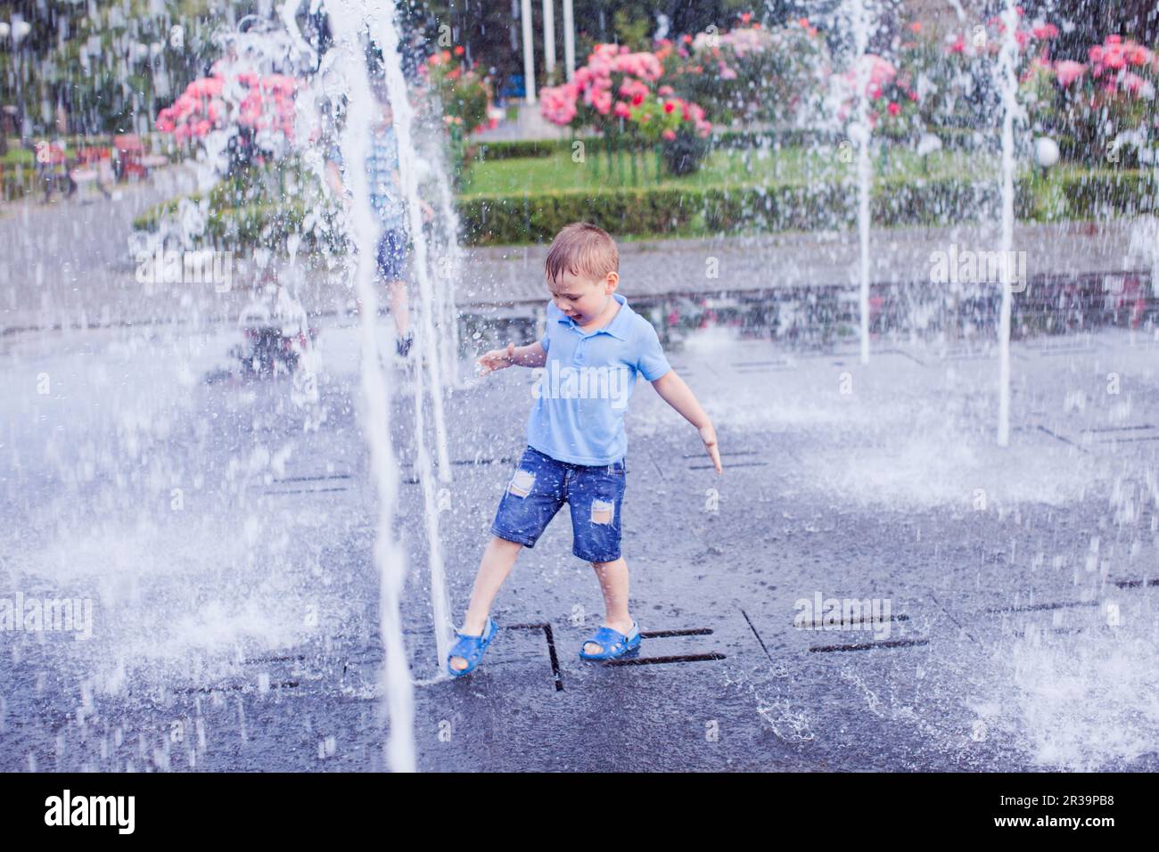 Little boy trying to stop the flow of water Stock Photo - Alamy