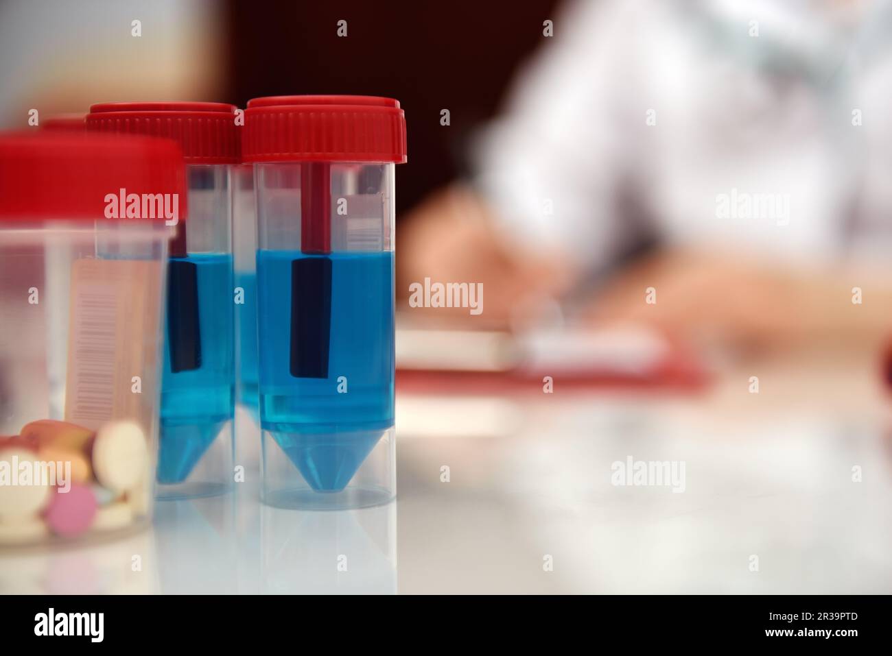 Blue Sample And Tablet On table. Woman Working In Clinic Stock Photo ...