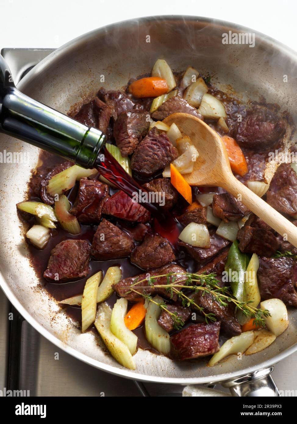 Beef ragout being deglazed with red wine Stock Photo - Alamy