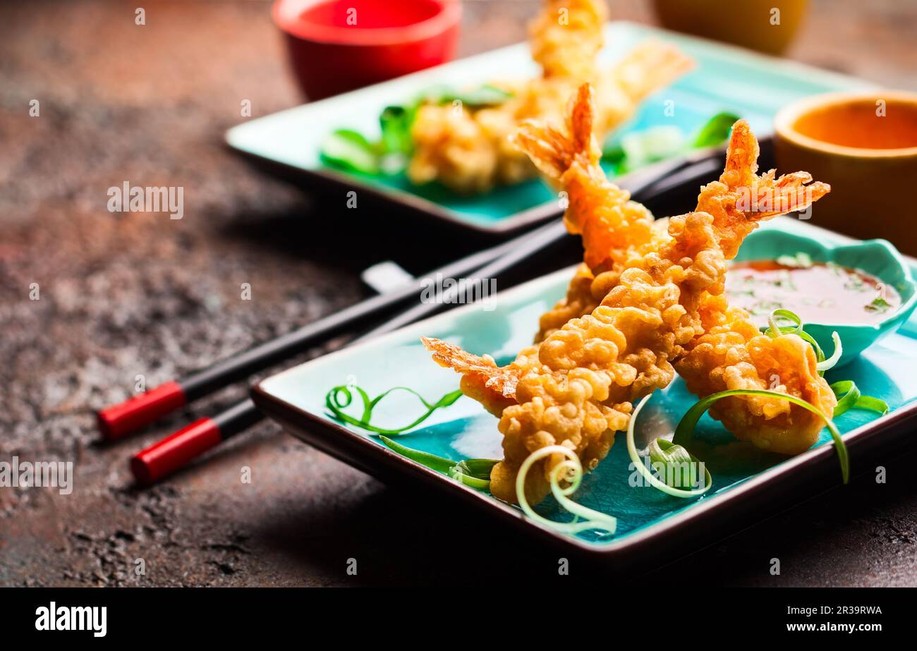 Shrimps tempura with spicy chili sauce on blue plate. Seafood tempura ...
