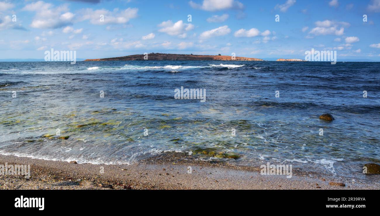 sea coast with pebbles. relaxing background with island on the horizon ...