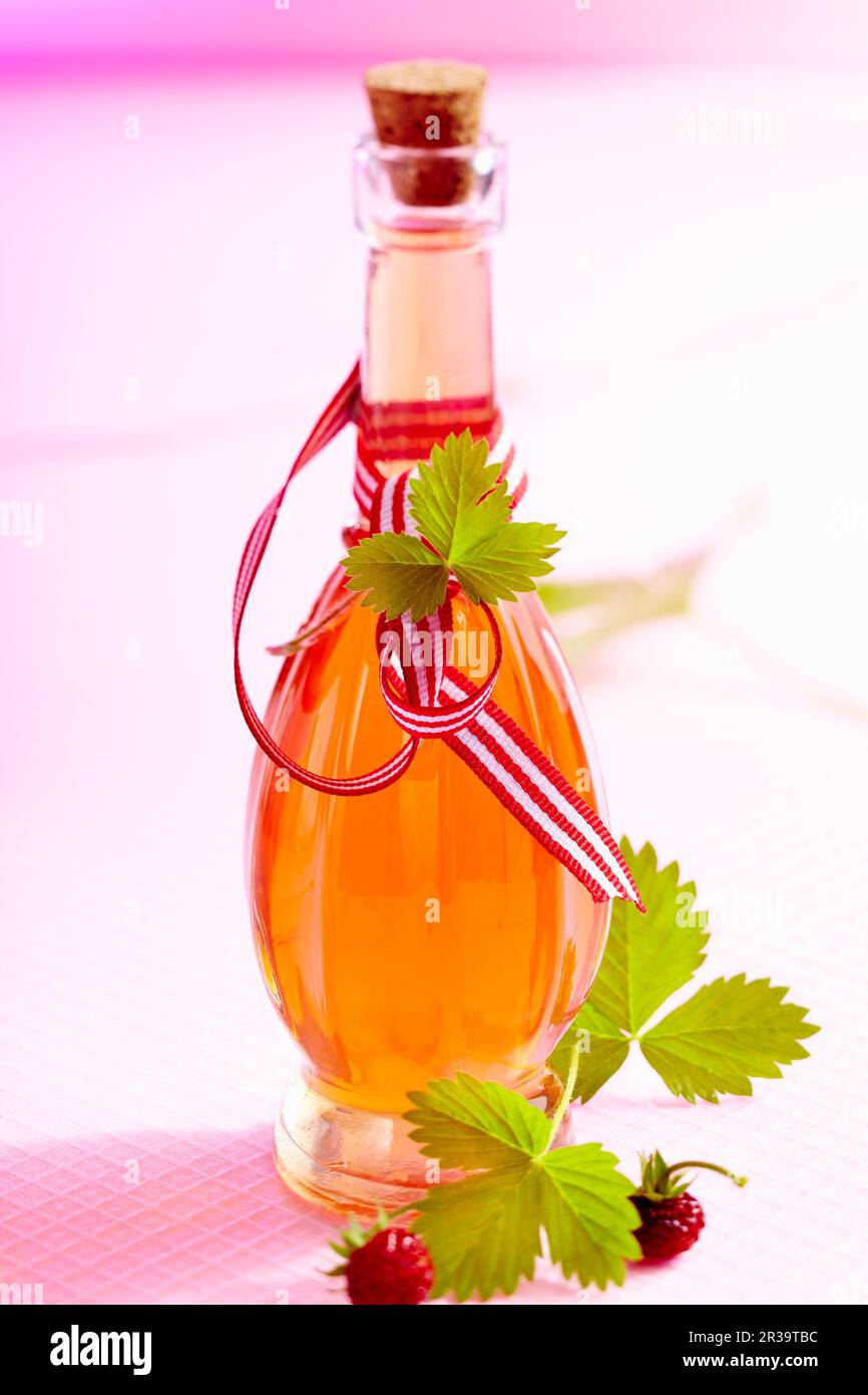 Homemade strawberry liqueur with fresh wild strawberries, wine spirit ...