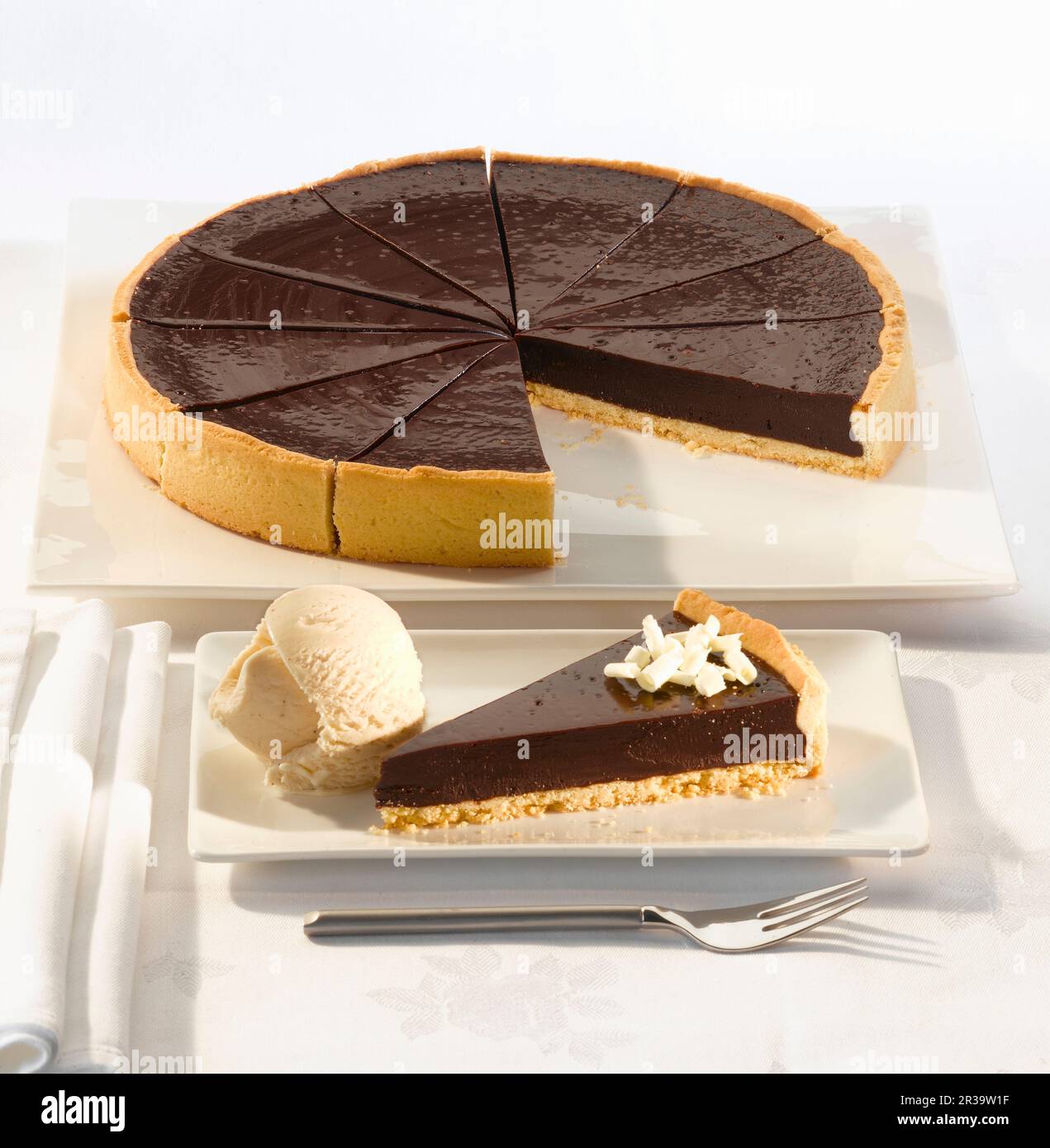 Chocolate torte for twelve servings in a pastry case with a scoop of ...