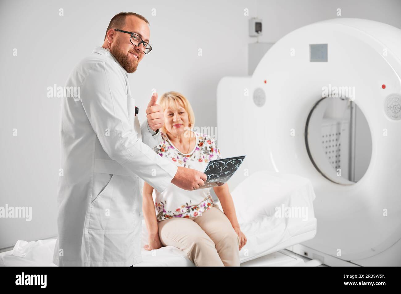 Medical computed tomography or MRI scanner. Doctor holding results of ...