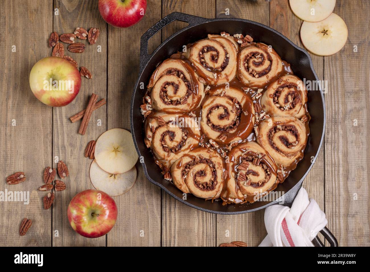 Apple pecan sticky buns with caramel sauce in a cast iron pan Stock ...