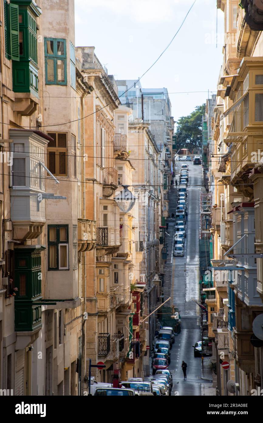 Steep street in Valetta with tall buildings Stock Photo - Alamy