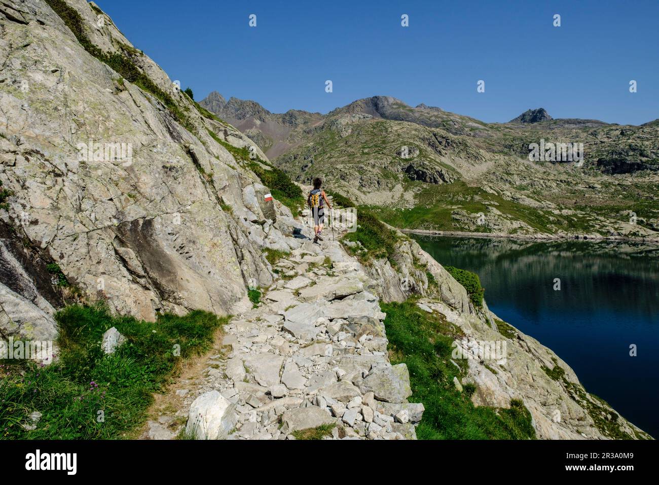 hiker on Bachimaña reservoir, Ibones azules and Bachimaña alto route ...