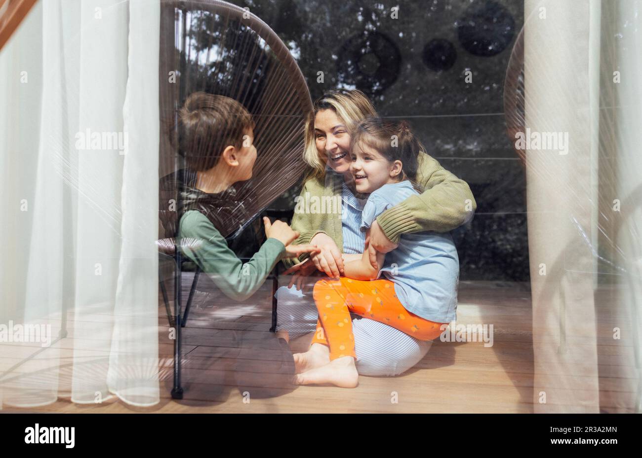 Happy family are sitting on the floor outside the panoramic window in ...