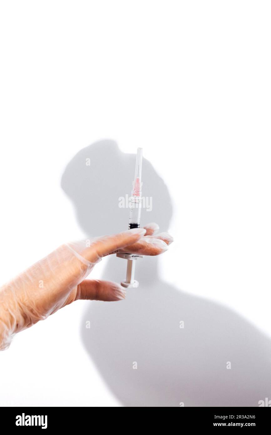 Close up of woman hand in medical transparent gloves holding syringe ...