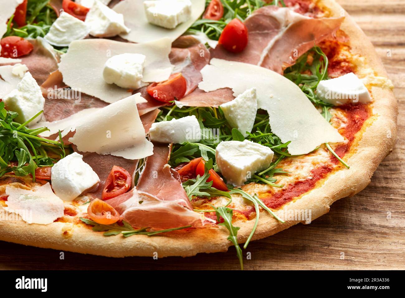 Pizza with cured ham, cheese and rocket Stock Photo - Alamy
