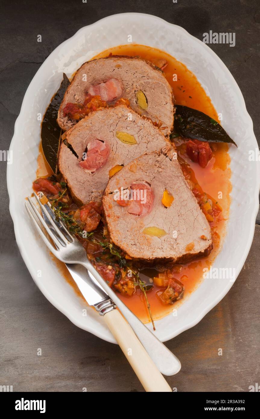 Stuffed pork roulade in a vegetable stock Stock Photo - Alamy