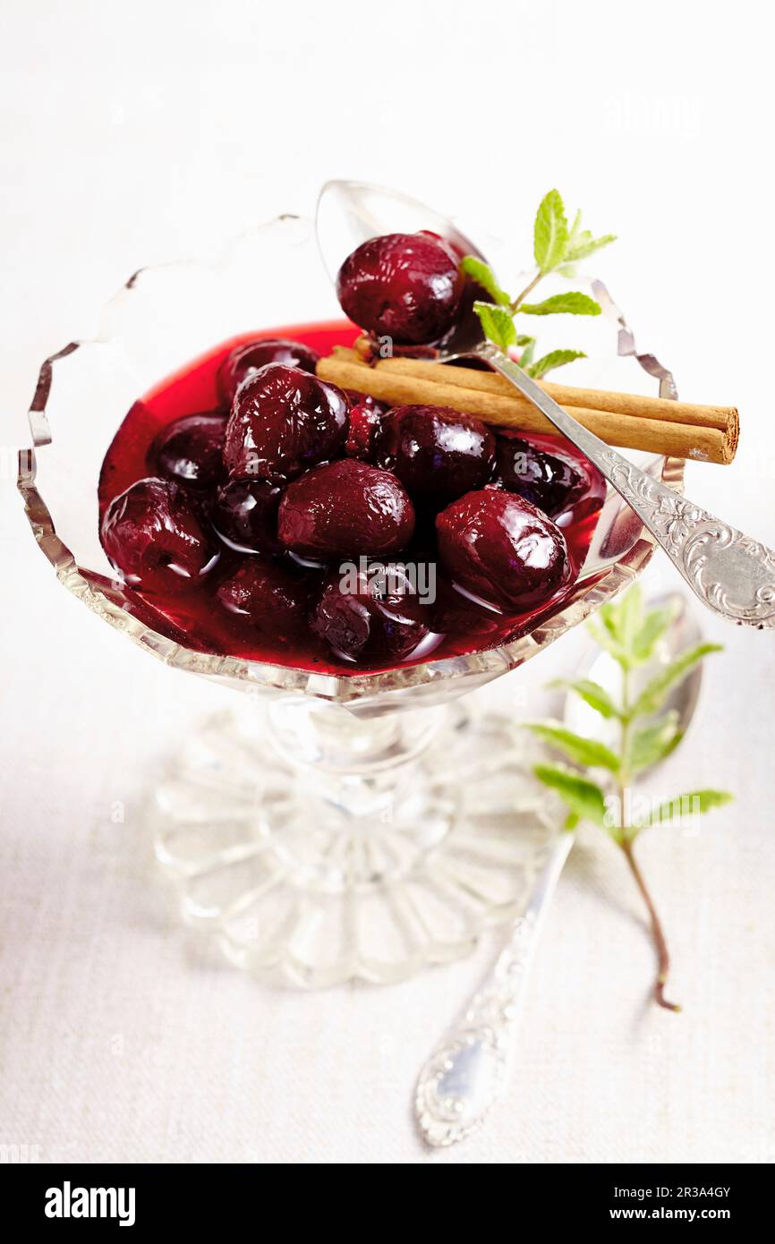 Sour cherries in syrup with lemon, cinnamon and mint Stock Photo - Alamy