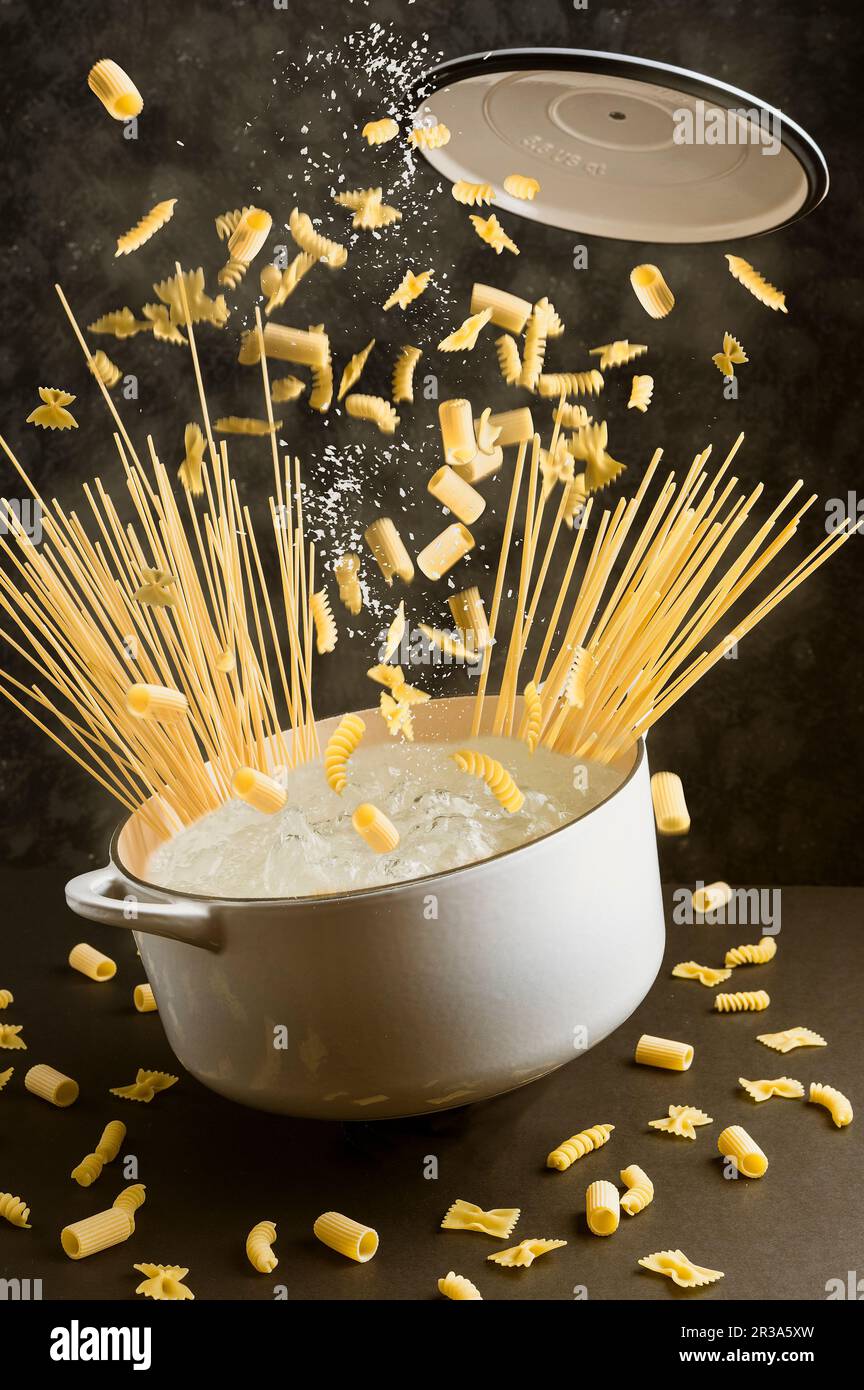 Various types of pasta falling into boiling water Stock Photo - Alamy