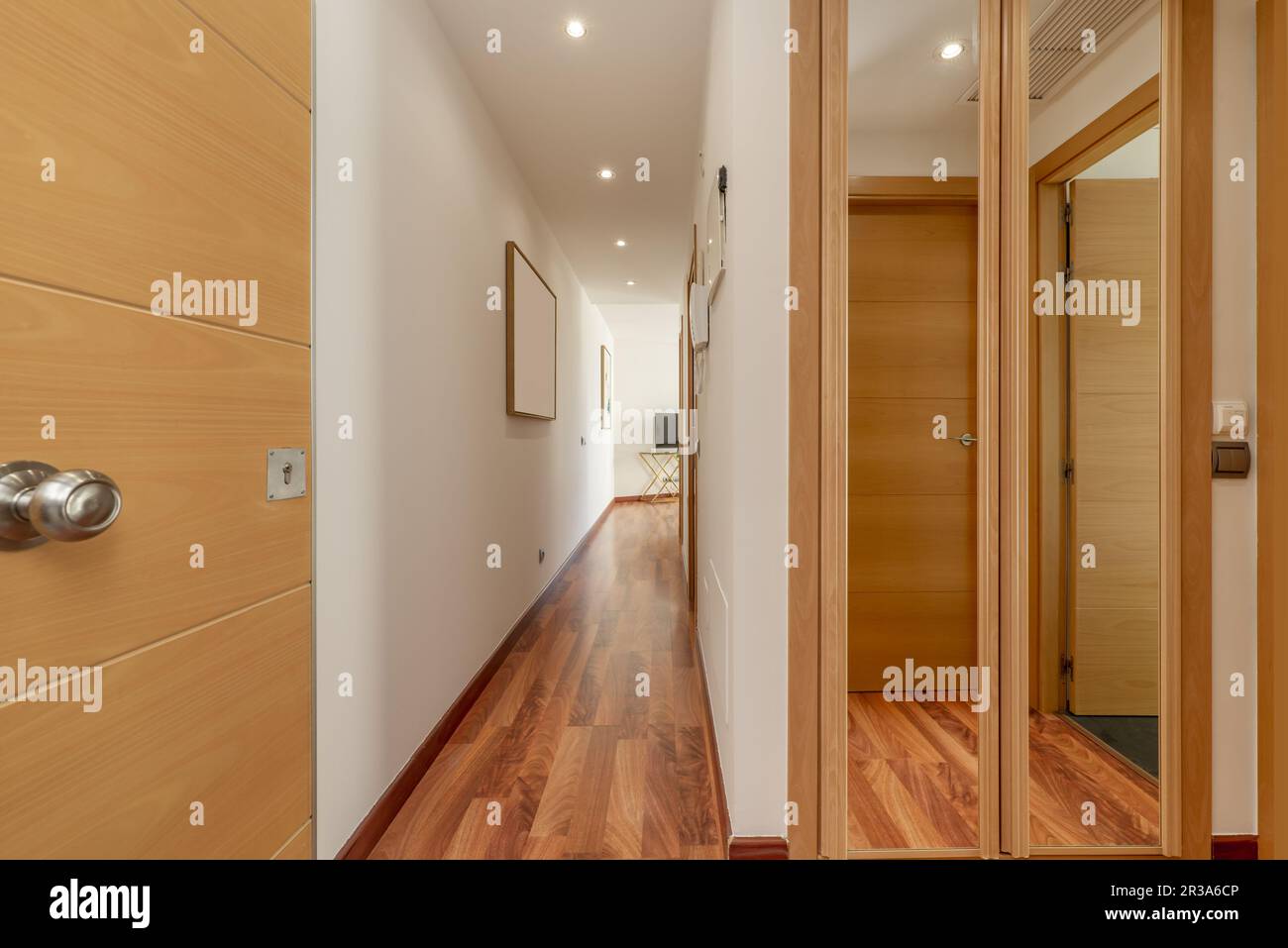 Entrance hall of a house with a long hallway with fitted wardrobes with ...