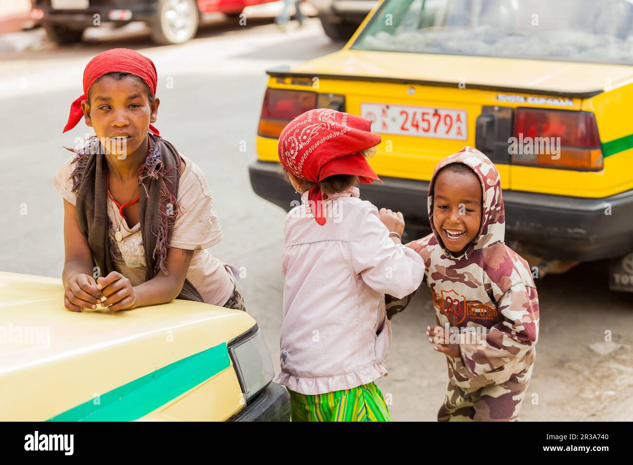 Three small orphan street kids playing and laughing on a quite city ...