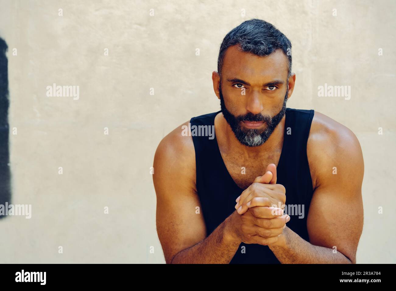 A determined male athlete in sports clothing, working out at the gym to ...