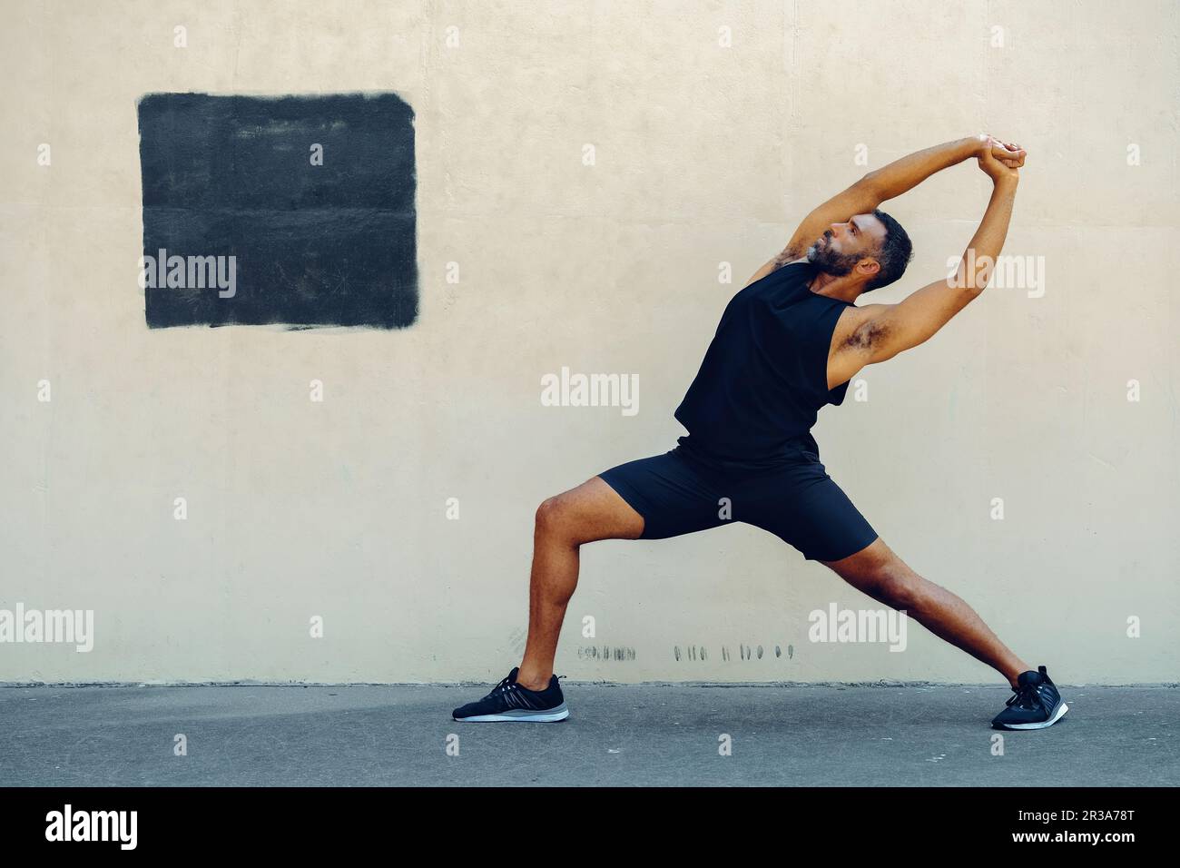 Man exercising in squat leg and stretching arms Stock Photo - Alamy