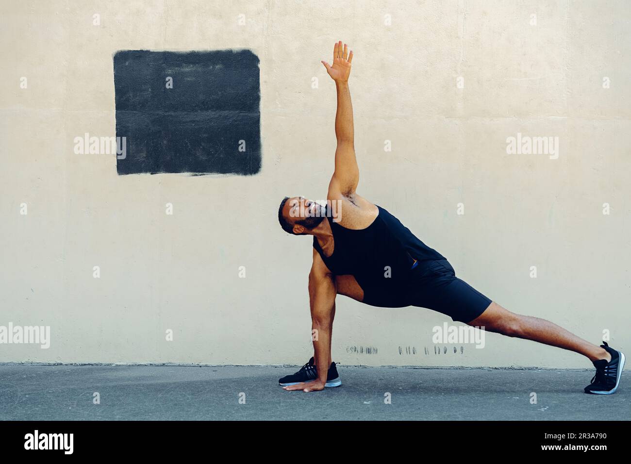 A fit athlete wearing sports clothing is exercising indoors to increase ...