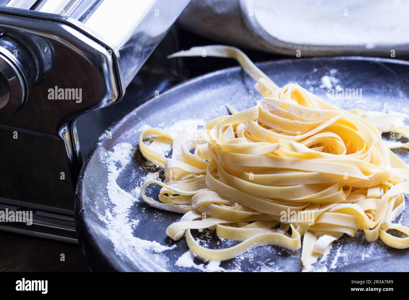 Homemade pasta on a plate in front of a pasta machine Stock Photo - Alamy