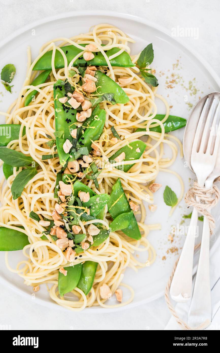 Spaghetti with mange tout, basil and peanuts Stock Photo - Alamy