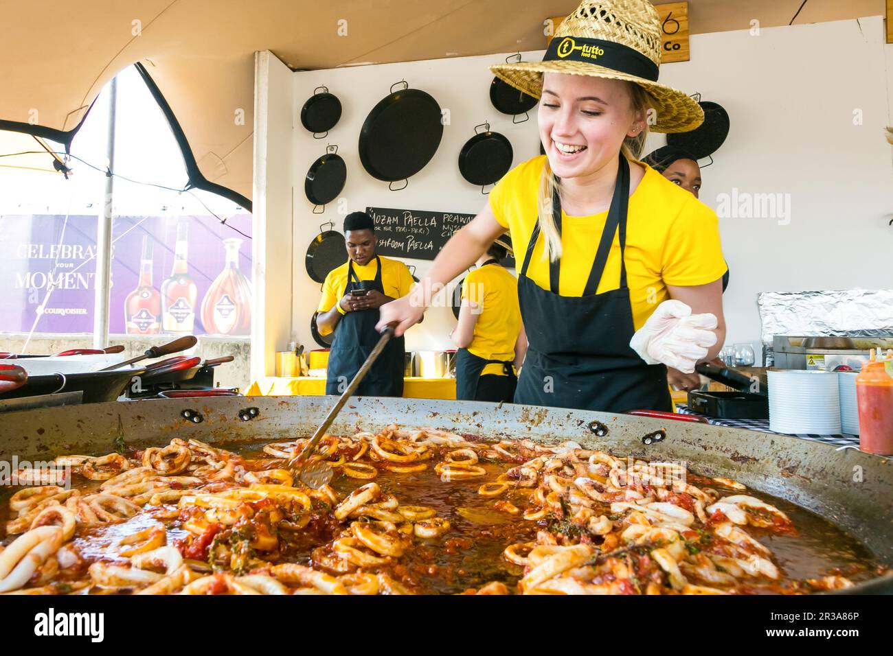 Caucasian Female Chef making and serving Paella Seafood take-away meals ...