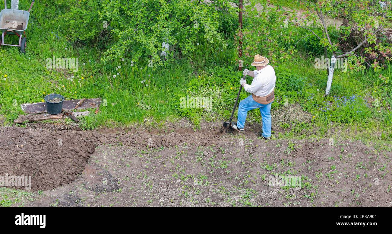 Man in country digs shovel hi-res stock photography and images - Alamy