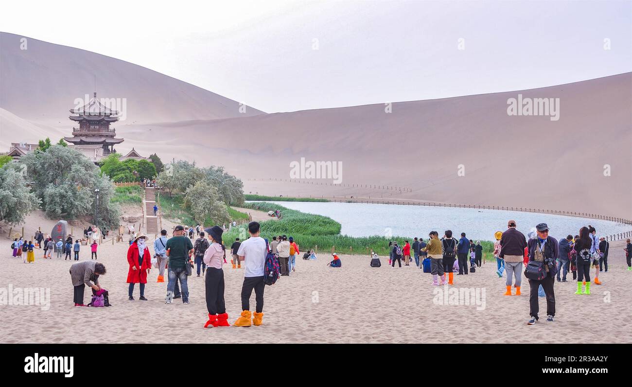 Tourists visit the Mingsha Mountain and Yueya Spring scenic area in ...