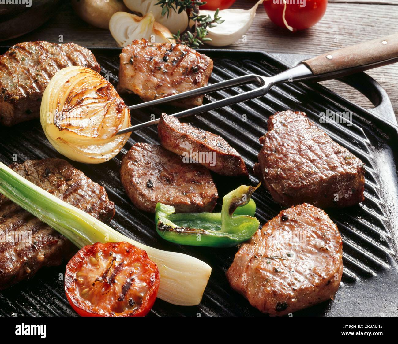 Various meats and vegetables on a grill Stock Photo - Alamy
