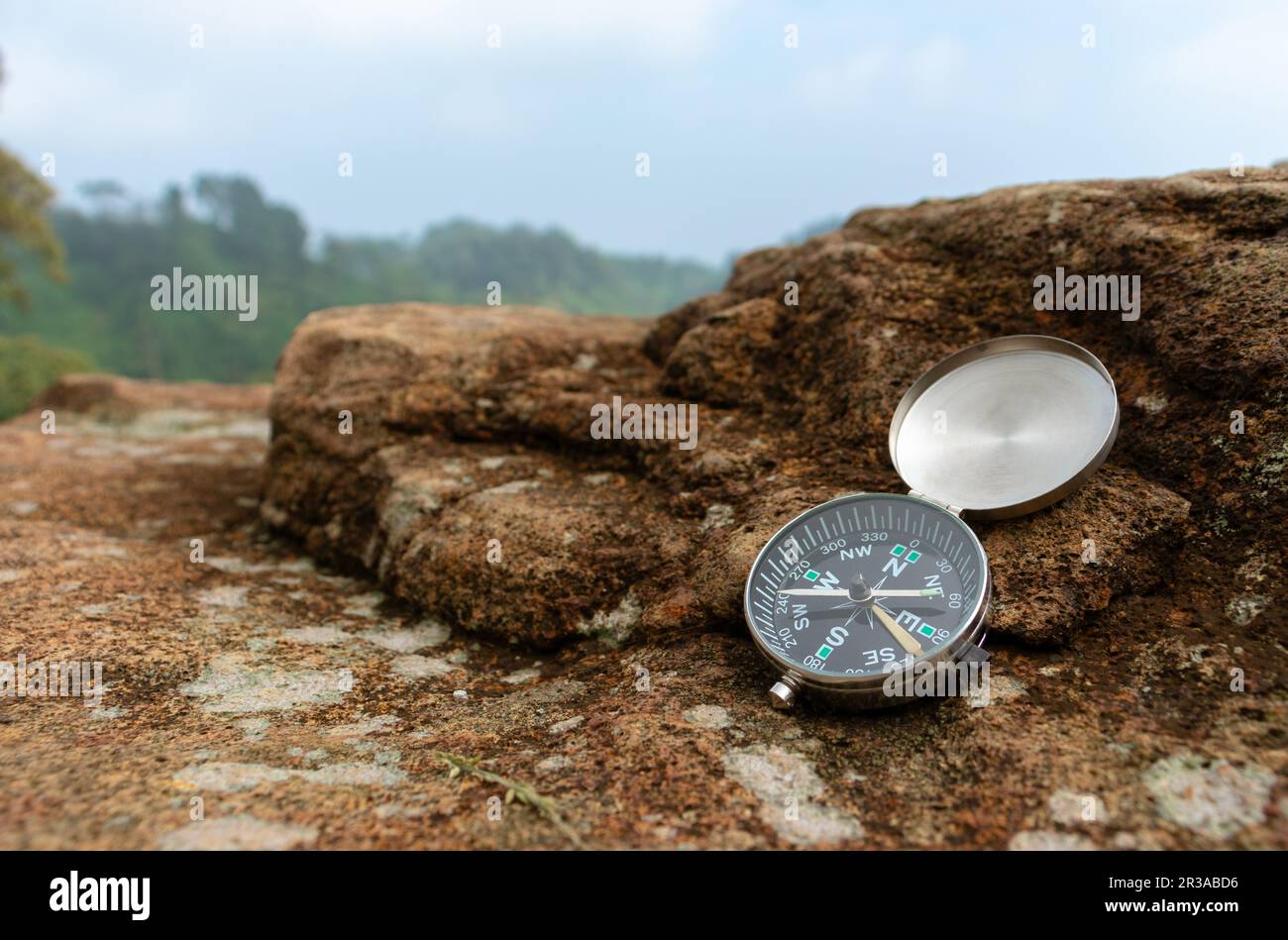 Concept for traveling and adventure. A compass placed on a giant rock ...