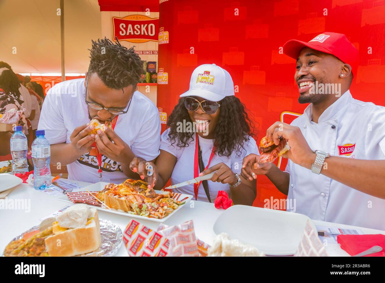 Diverse African judges tasing and scoring meals at cooking competition ...