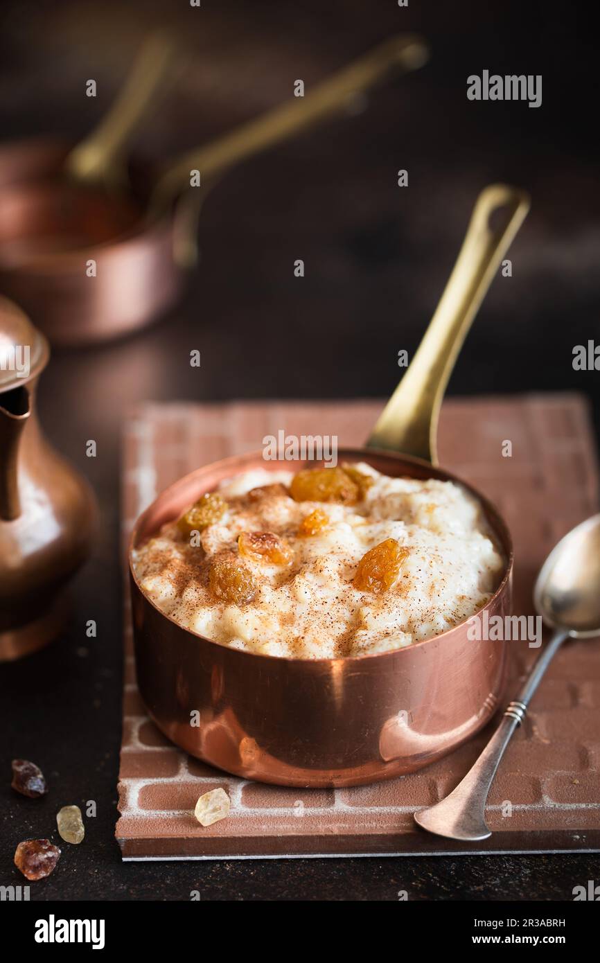 Oatmeal porridge with raisins and cinnamon in a copper cocotte. Oatmeal ...