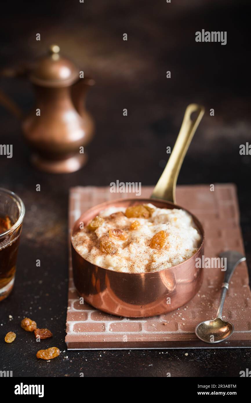Oatmeal porridge with raisins and cinnamon in a copper cocotte. Oatmeal ...