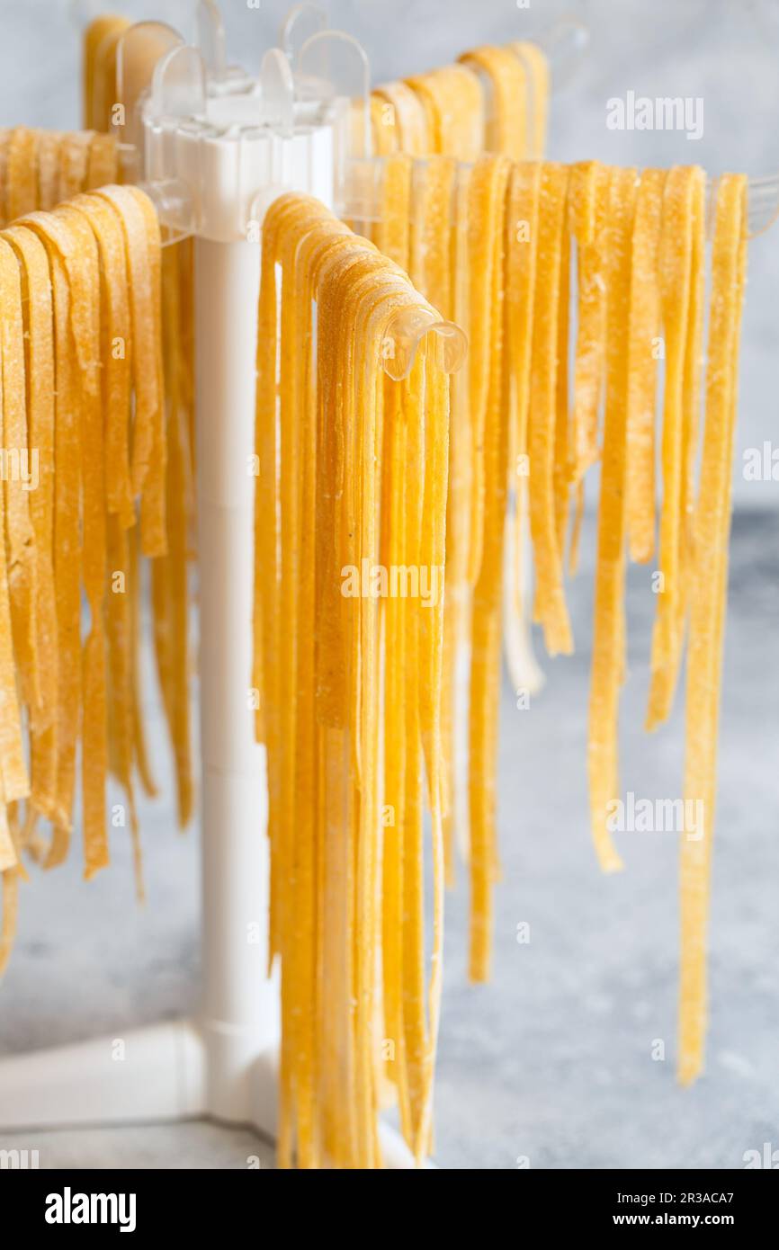 Homemade pasta linguine hanging on rack to dry. Homemade Italian ...