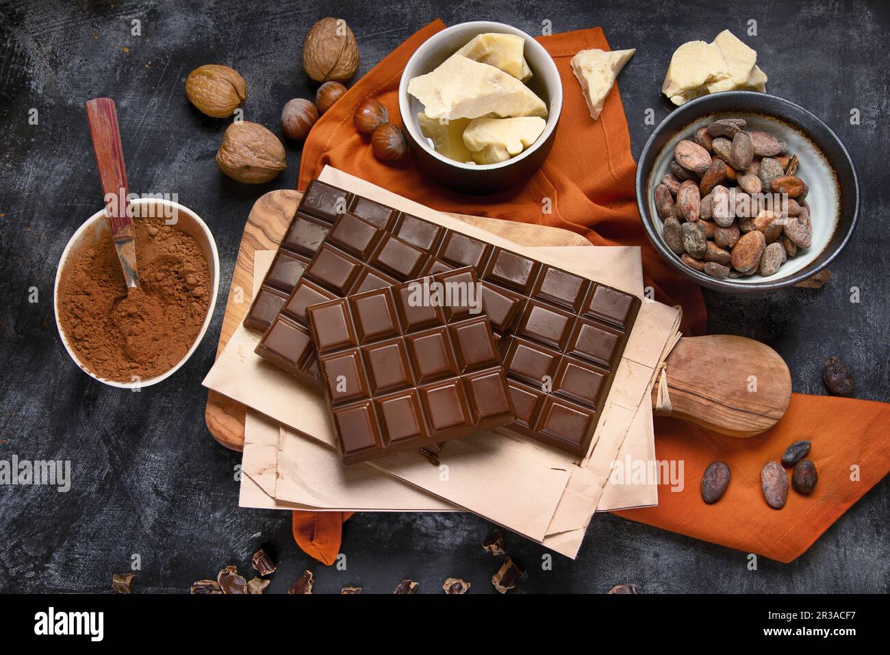 Bars of chocolate, cacao powder, cacao butter and cacao beans on black ...