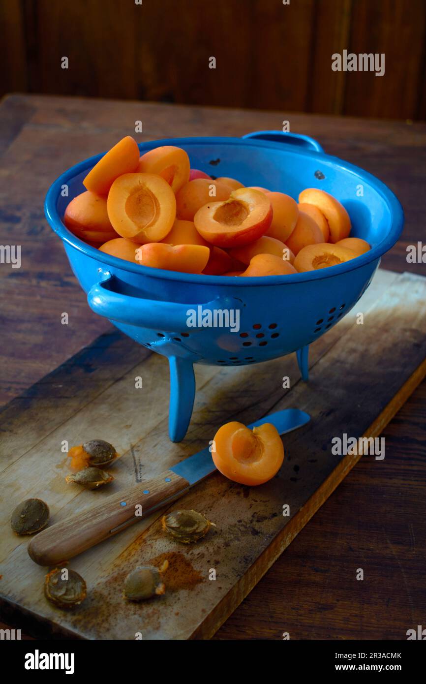 Fresh apricots, whole and pitted in a blue colander Stock Photo - Alamy