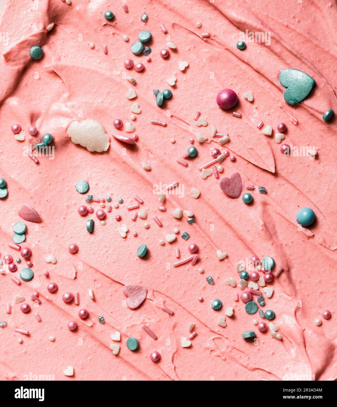 Pink buttercream with coloured pearls and hearts Stock Photo - Alamy